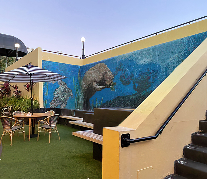 The outdoor courtyard's manatee mural watches over diners enjoying Florida sunshine with their meals, creating a uniquely Floridian ambiance.