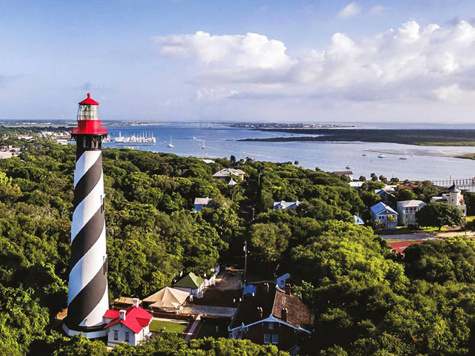 The St. Augustine Lighthouse stands tall against the blue Florida sky, its distinctive black and white spiral pattern a beacon for both sailors and spirits.