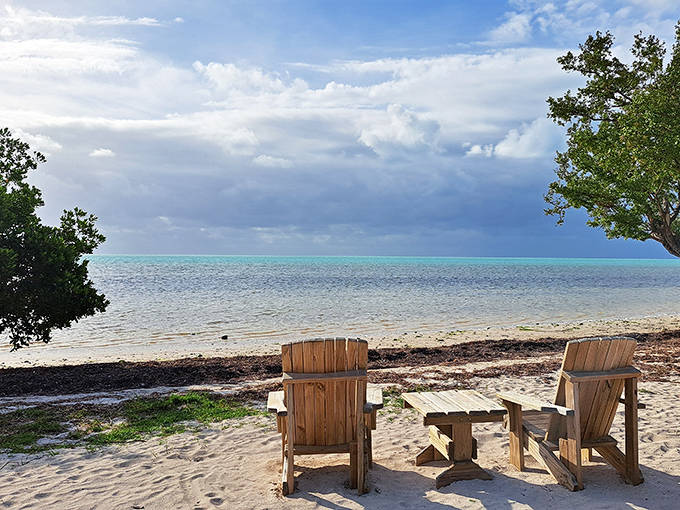 Two wooden Adirondack chairs facing the calm waters at Long Key, creating the perfect front-row seats for nature's best show.