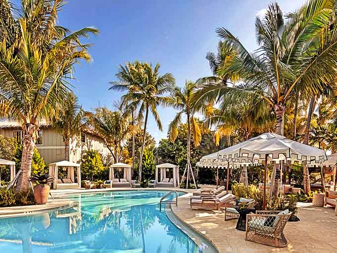 Palm trees frame the curving pool at Little Palm Island, where private cabanas await couples seeking island seclusion.