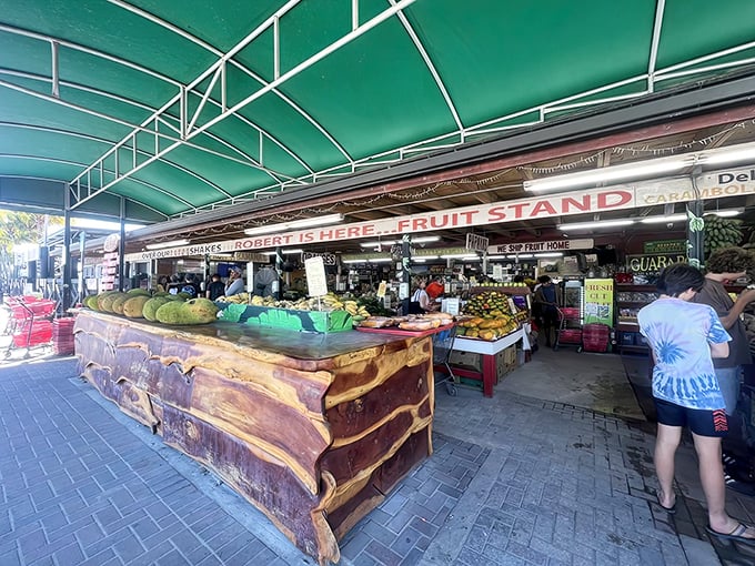 Robert Is Here fruit stand welcomes visitors with its iconic green awning and rustic wooden counter, showcasing exotic fruits rarely found elsewhere in Florida.