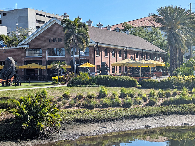 Ulele's brick building stands proudly along Tampa's Riverwalk, yellow umbrellas inviting diners to enjoy the waterfront setting.