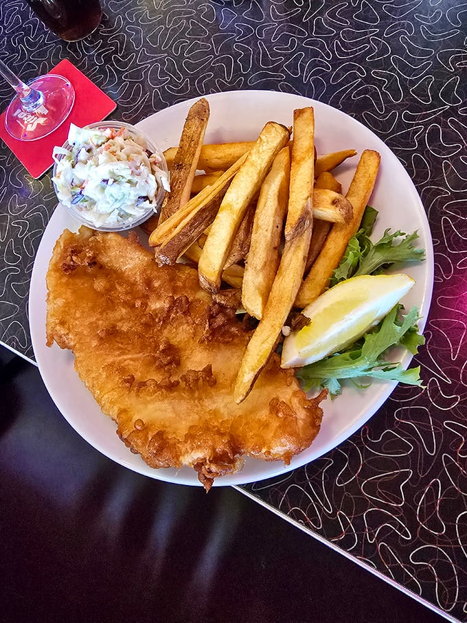 Golden fish and chips perfection! Crispy batter hugs flaky white fish alongside thick-cut fries and creamy homemade coleslaw &ndash; the UK's finest comfort food done right.