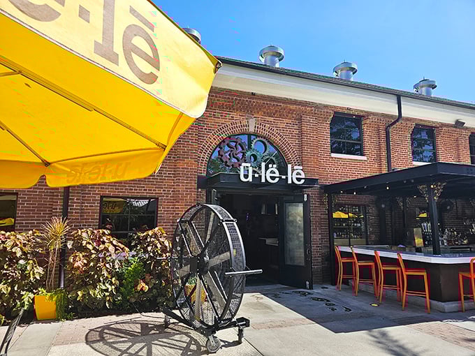 The welcoming entrance to Ulele features brick architecture and outdoor seating, promising a unique Tampa dining experience.