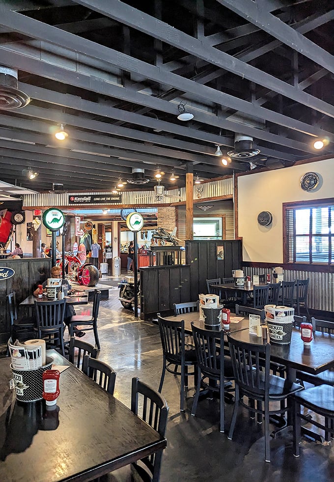 Industrial-chic meets roadhouse comfort in the main dining area, where exposed beams and corrugated metal create an atmosphere that's both rugged and welcoming.
