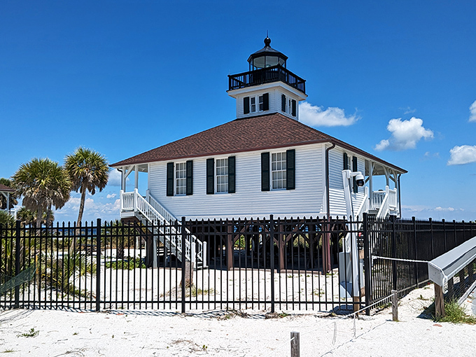 The historic Port Boca Grande Lighthouse stands sentinel on the island's southern tip, its white facade gleaming against the azure Gulf backdrop.