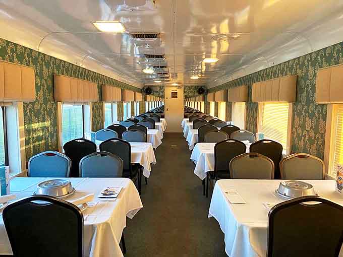 Elegant place settings await amateur sleuths in the dining car, where damask wallpaper and white tablecloths set the stage for culinary intrigue.