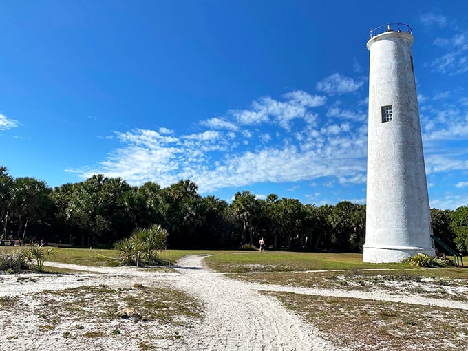 The historic lighthouse stands sentinel over Egmont Key, its whitewashed tower a beacon of maritime history against Florida's azure sky.