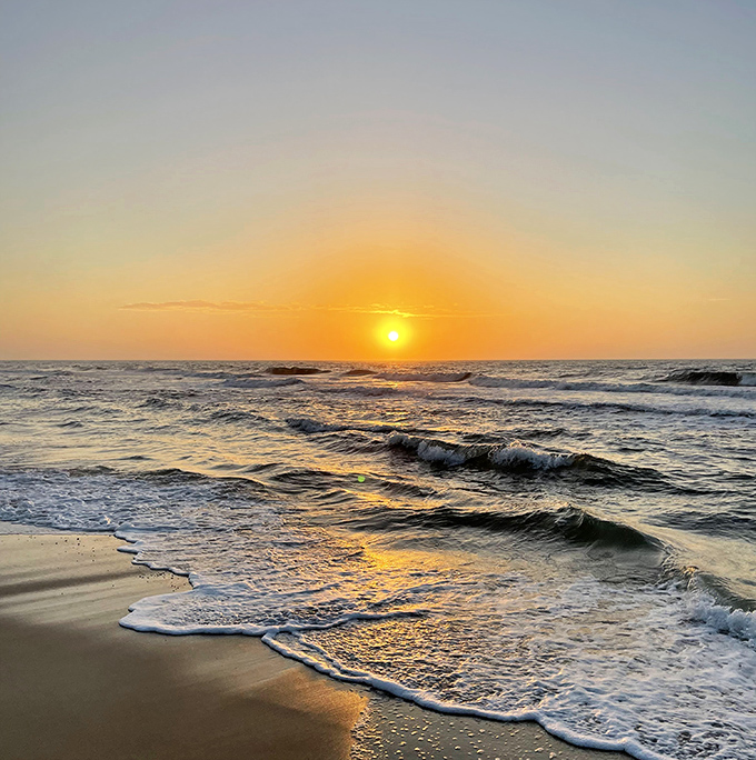A golden sunset paints the Gulf waters at St. George Island, where gentle waves create a hypnotic rhythm against the unspoiled shoreline.