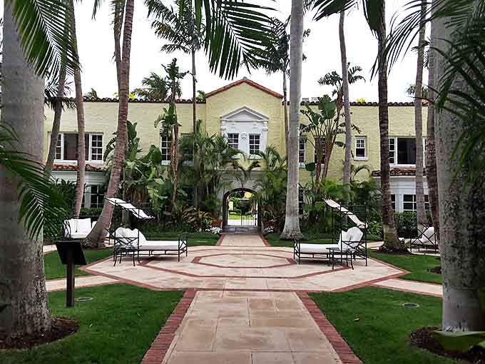 Lush palm trees surround the Brazilian Court's courtyard, where Mediterranean architecture creates a secluded oasis for romantic escapes.