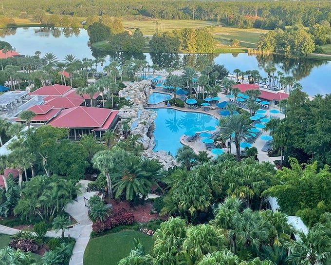 A bird's eye view reveals the resort's sprawling pool complex nestled among lush greenery, like a tropical oasis.