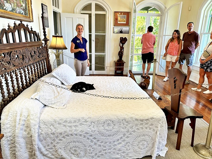 The master bedroom features an ornate carved headboard and period furnishings&mdash;complete with a feline guardian napping on duty.