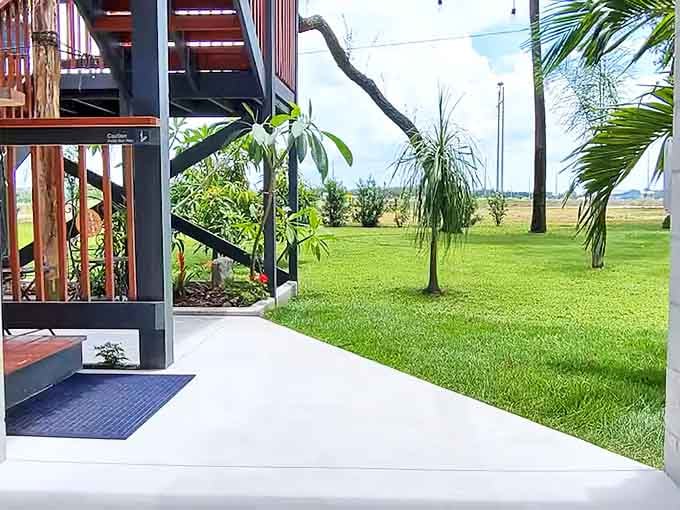 A lush carpet of green stretches beneath the stilted sanctuary, where nature provides the most soothing welcome mat imaginable.