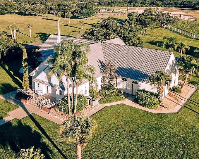 This charming white chapel at Westgate River Ranch offers a serene countryside setting, surrounded by palm trees and open Florida skies.