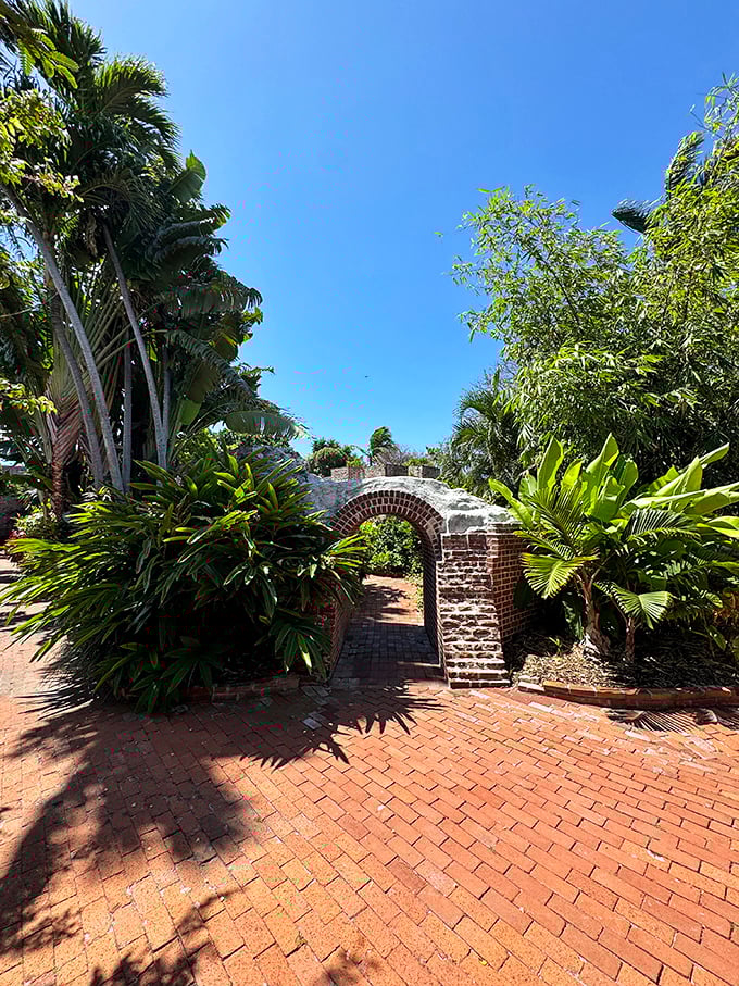 Civil War-era brick arches frame a tropical paradise, where cannons once stood ready but flowers now reign supreme.