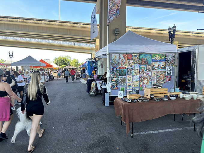 Visitors browse handcrafted items at Jacksonville's Riverside Arts Market, where the space under the Fuller Warren Bridge becomes a creative community gathering spot.