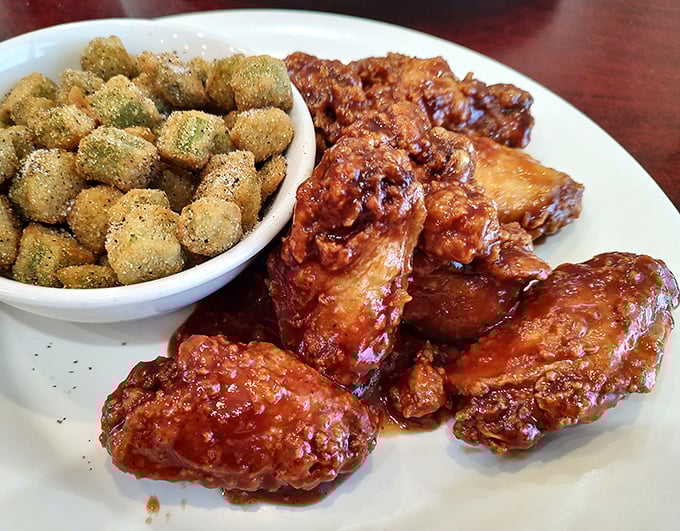 Wing heaven! Crispy, saucy chicken wings nestled beside golden-fried okra &ndash; proof that sometimes the simplest diner food delivers the most satisfaction.