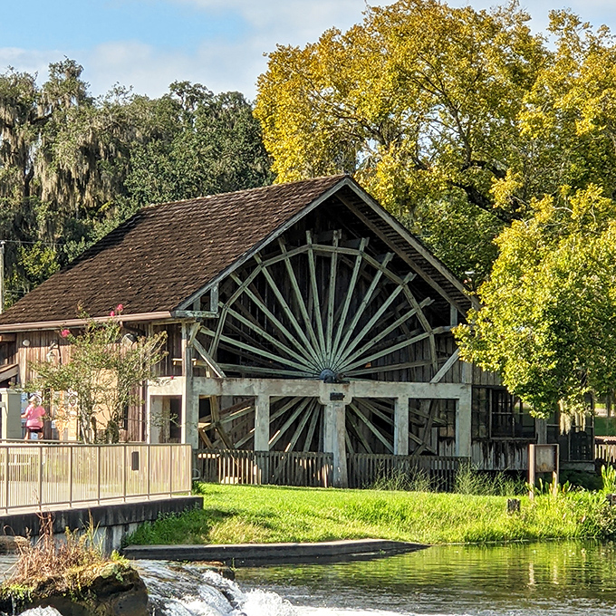 Rustic wooden beams frame the iconic water wheel at this historic mill, where pancakes and nature create the perfect Florida day trip experience.