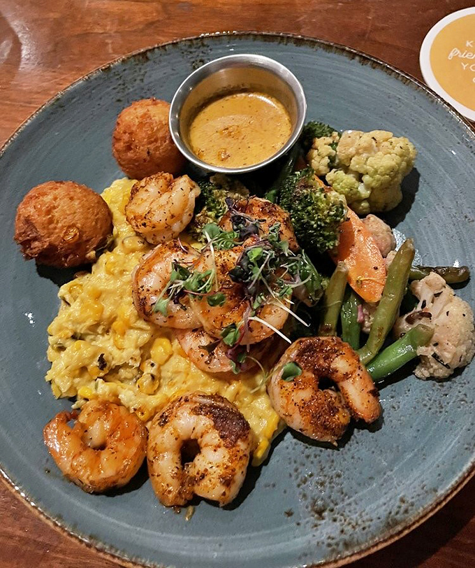 Blackened shrimp nestled on creamy grits &ndash; proof that sometimes the simplest combinations create the most profound flavors. Those hushpuppies deserve their own fan club.