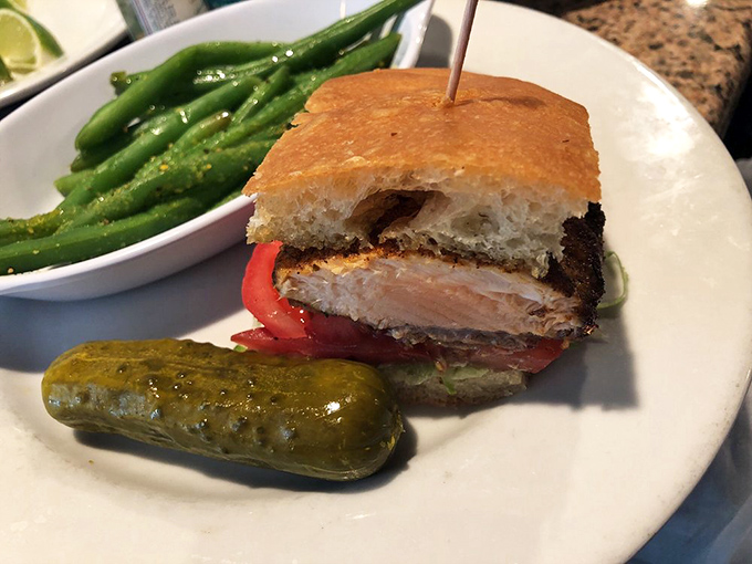 This Blackened Salmon BLT isn't just a sandwich&mdash;it's architecture with attitude, flanked by crisp green beans and a pickle sentinel.
