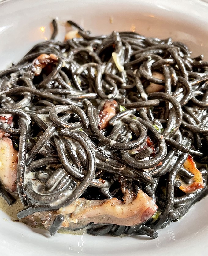 Inky black strands of squid pasta intertwined with tender seafood &ndash; proof that sometimes the most dramatic-looking dishes deliver equally dramatic flavors.