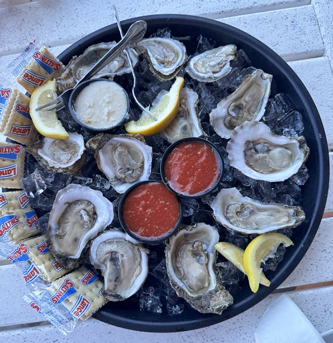 Fresh oysters on the half shell arrive like jewels on ice, accompanied by zesty cocktail sauce and lemon wedges&mdash;ocean treasures waiting to be savored.