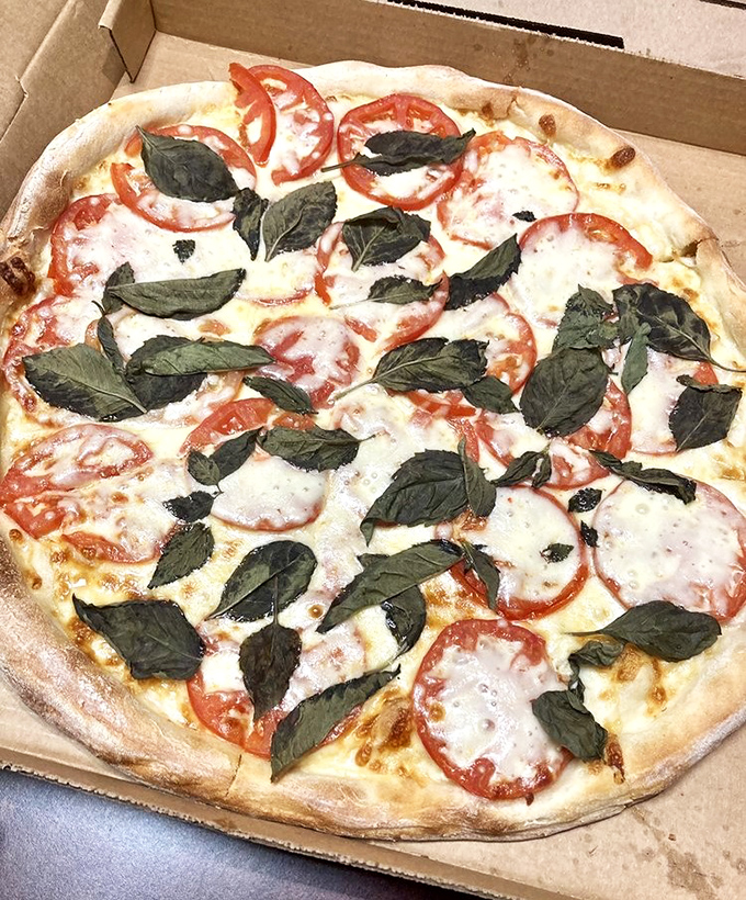 Fresh basil leaves dance atop perfectly melted cheese and bright tomato slices&mdash;a Margherita pizza that would make Naples proud.