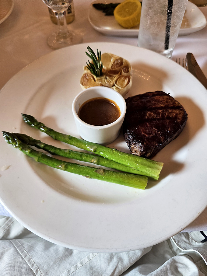A perfectly seared filet mignon shares the spotlight with rosemary-infused potatoes and vibrant asparagus &ndash; simplicity elevated to art form.