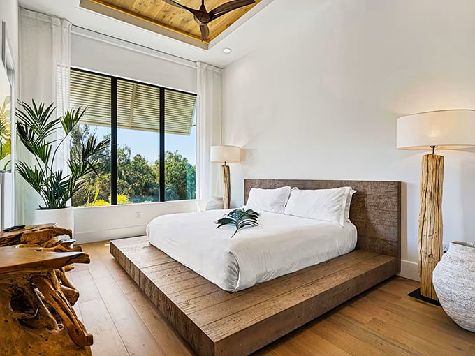 Drift into dreamland in this serene bedroom where wooden ceiling warmth contrasts with crisp linens and natural light floods through.