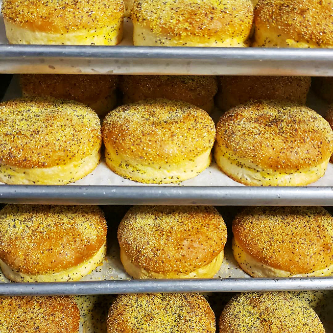 Golden English muffins lined up like delicious dominoes, waiting to embrace juicy patties and become the perfect burger delivery system.