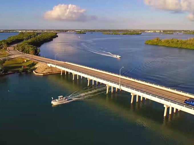 Bridges along the Indian River Lagoon Byway connect barrier islands to the mainland, with boats dotting the sparkling waters below.
