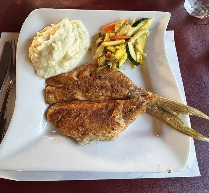Broiled Yellowtail Snapper: Golden-crusted yellowtail rests beside creamy mashed potatoes, a Florida seafood symphony that's been playing to standing ovations since the Roaring Twenties.