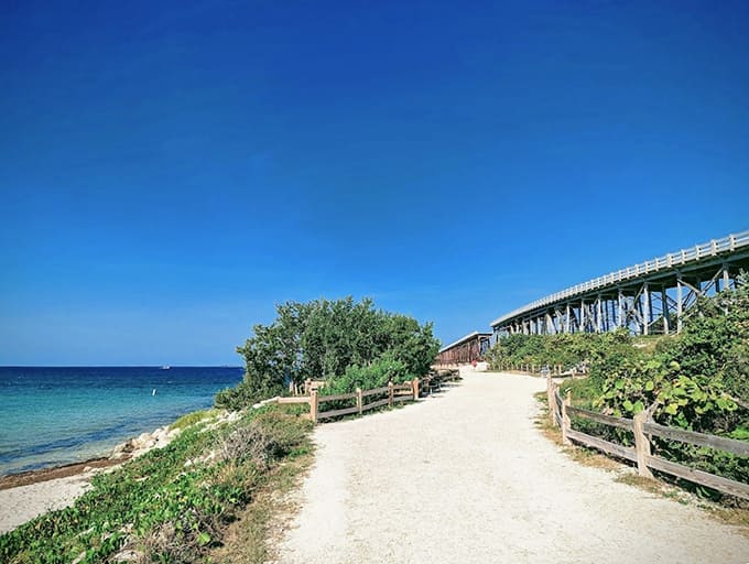 A coastal path winds between turquoise waters and native vegetation under the bluest Florida sky imaginable.