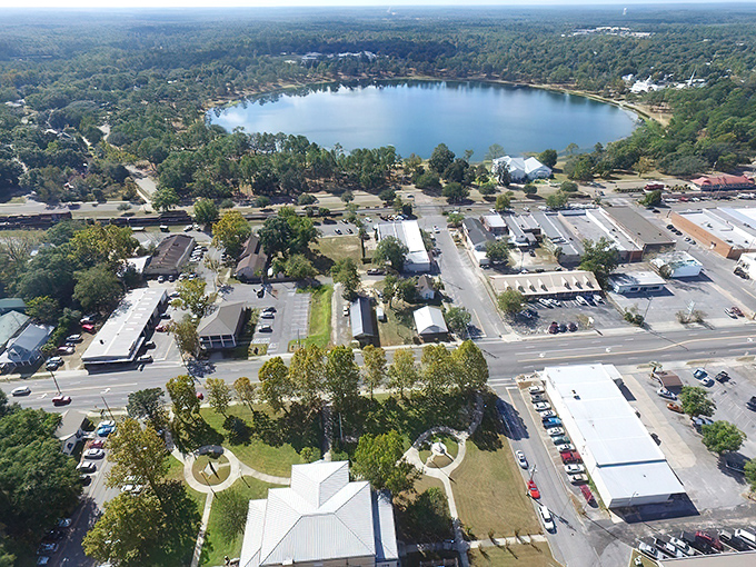 DeFuniak Springs' perfectly round lake creates a stunning centerpiece for this historic town, with buildings and greenery reflected in its mirror-like surface.