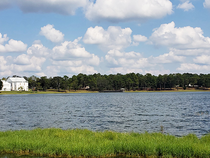 The serene waters of Lake DeFuniak reflect the blue sky and surrounding landscape, showcasing why this rare circular spring-fed lake draws visitors year-round.