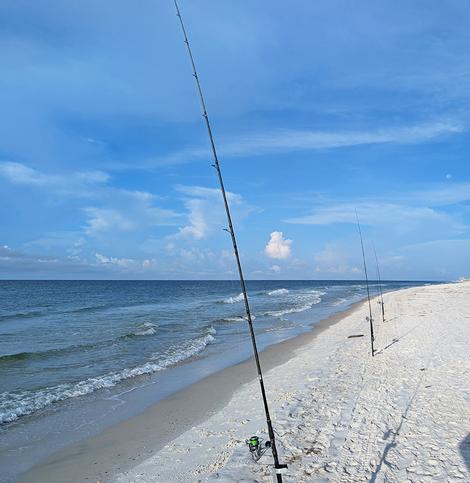 Fishing poles stand sentinel against the horizon, patient anglers hoping to catch dinner while enjoying nature's spectacular show.