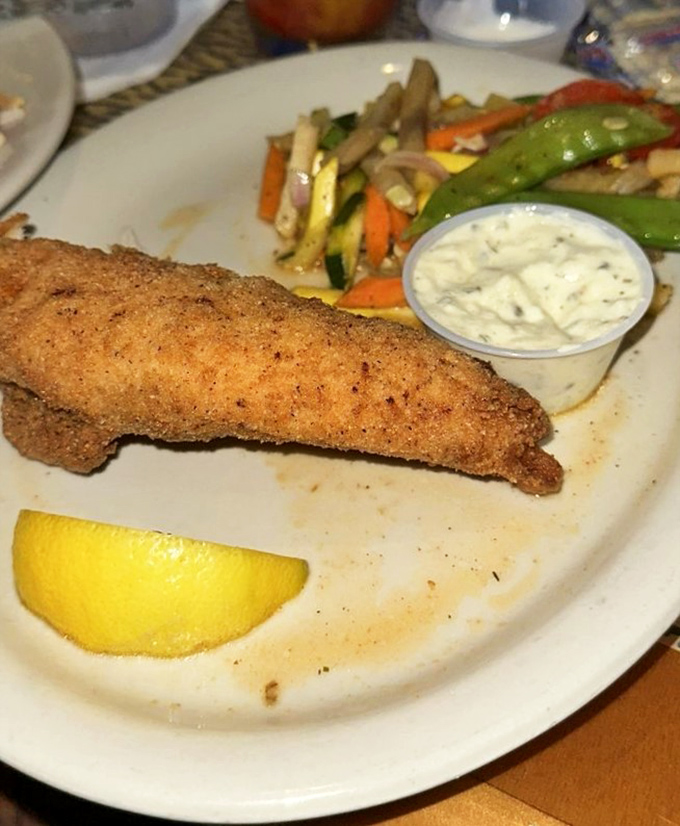 A perfectly seasoned fish fillet, golden-brown and crispy outside, flaky and moist inside &ndash; served with fresh vegetables and homemade tartar sauce.
