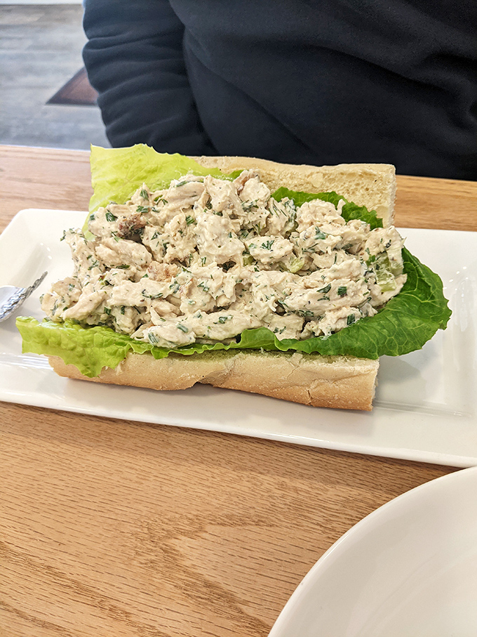 A generous portion of freshly made tuna salad nestled on crisp lettuce between slices of perfectly toasted bread.