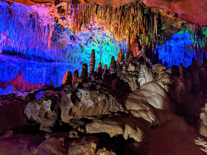 A kaleidoscope of colored lights reveals the intricate textures and formations that water has patiently sculpted over countless millennia.