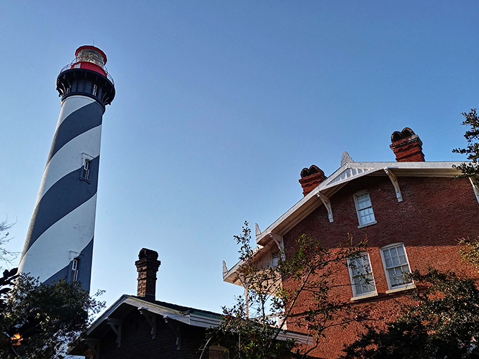 St. Augustine's iconic black and white lighthouse stands tall against the blue sky, a historic beacon that's guided sailors for generations.