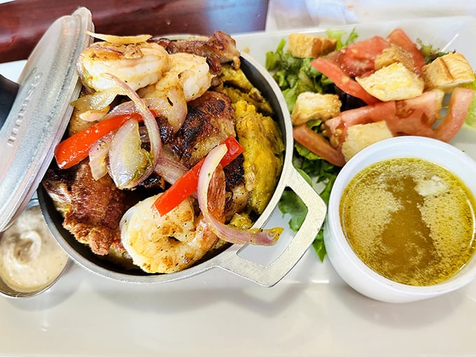 Sizzling skillet magic! Plump shrimp, seasoned meats, and colorful peppers create a feast for both eyes and taste buds, served with fresh salad and golden dressing.