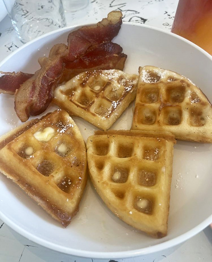 Golden waffle quarters with a side of bacon &ndash; breakfast simplicity elevated to an art form through perfect execution.
