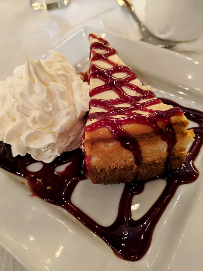 A slice of cheesecake that's dressed more elegantly than most Gilded Age visitors were. That raspberry drizzle is practically wearing a tuxedo!