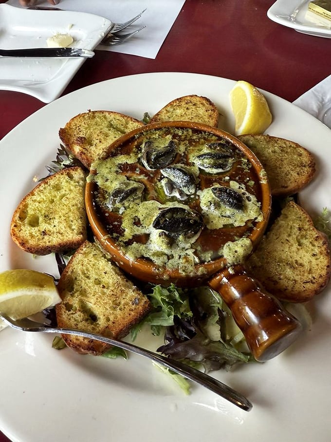Escargot served in traditional fashion with garlic butter and toast points &ndash; a nod to the fine dining heritage that has always coexisted with Cap's rustic charm.