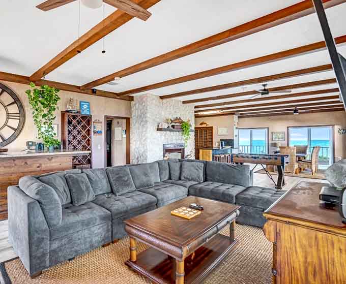 The living room's exposed beams and comfortable seating create that perfect vacation vibe where doing absolutely nothing feels like an accomplishment worth celebrating.