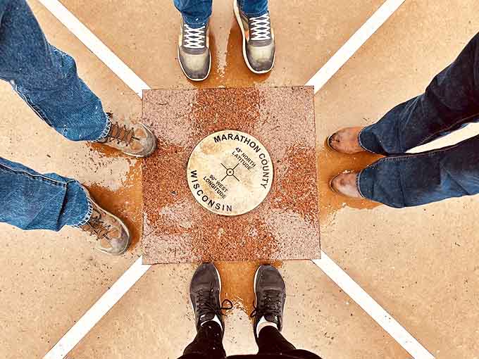 Hands reaching to touch the marker create a connection between human curiosity and mathematical precision in Marathon County.