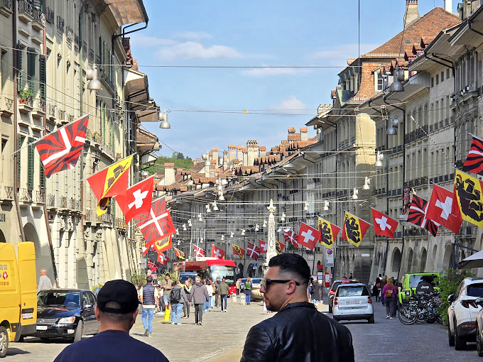 European charm meets Swiss precision in Bern's flag-lined streets, a world away from Florida's tree tunnels.