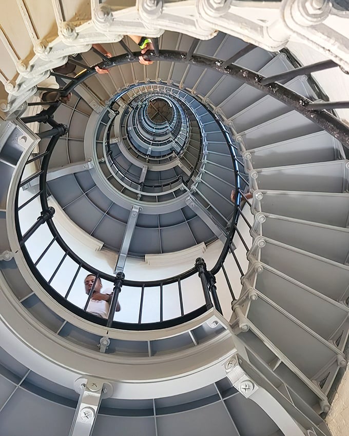 Looking up through the lighthouse's spiral staircase creates a mesmerizing vortex effect&mdash;203 steps of architectural wonder leading skyward.