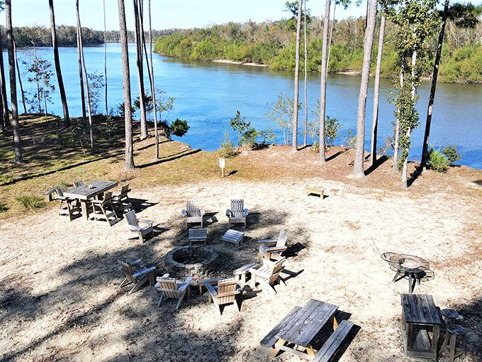 A campfire circle surrounded by Adirondack chairs with water views &ndash; St. Joseph's beach bonfire setup is conversation starter perfection.