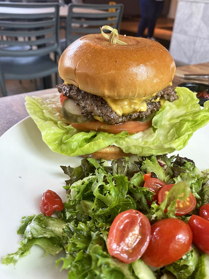 This isn't just any burger &ndash; it's a masterpiece of juicy perfection topped with fresh veggies and nestled beside a garden salad.